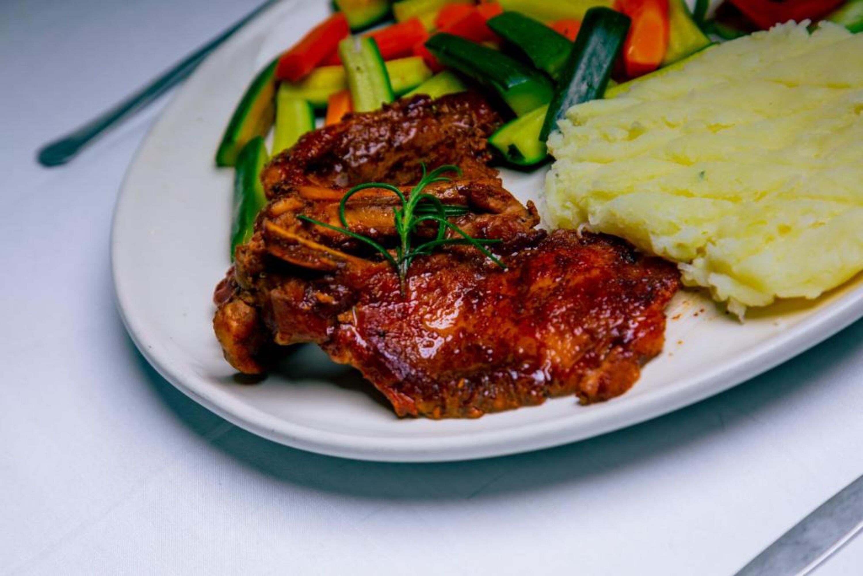 Um prato com carne, purê de batatas e legumes cozidos.