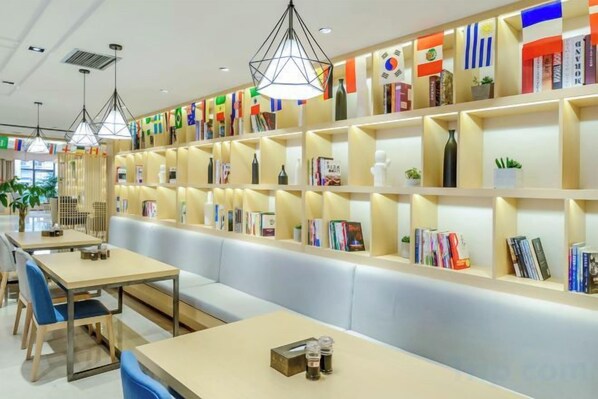 Uma biblioteca moderna com estantes, áreas de estar e iluminação pendente.