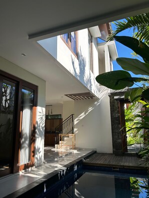 Uma casa moderna com piscina, escada e vista para o céu.