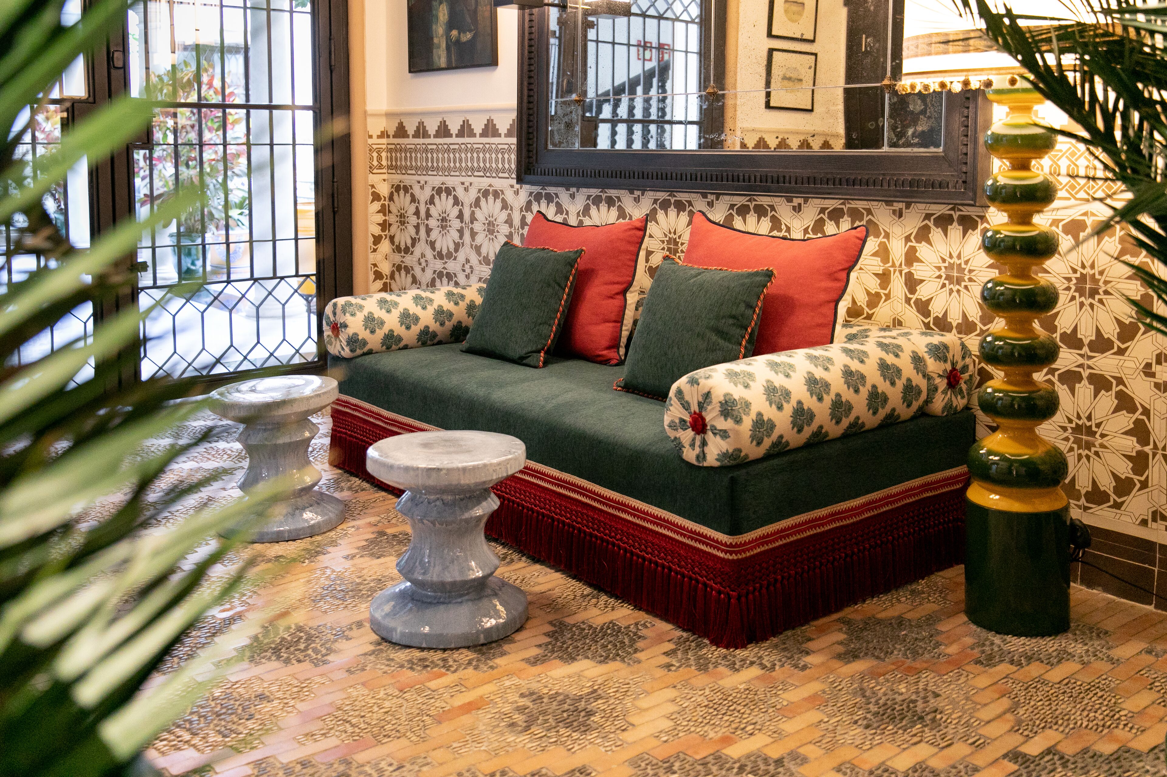 Uma área de estar acolhedora, com um sofá estampado, almofadas decorativas e um chão com padrão.