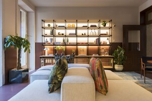 Uma sala de estar moderna com uma grande estante, assentos confortáveis e plantas decorativas.