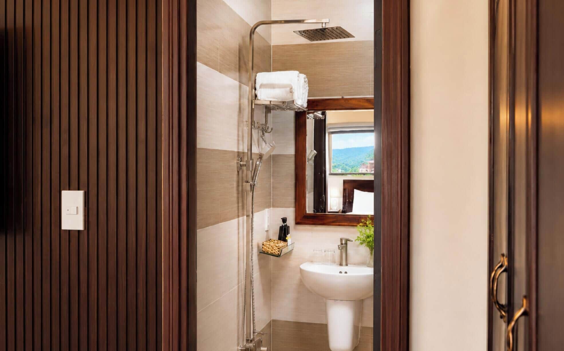 Uma casa de banho moderna com chuveiro, pia e janela com vista.