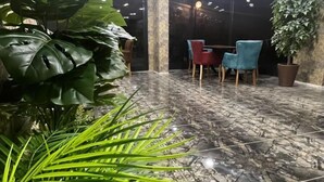 Um hall de entrada com piso de mármore, plantas verdes e mobiliário moderno.