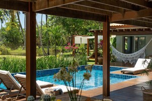 Uma área de piscina com espreguiçadeiras e uma rede.