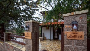 A stone entrance gate with signs reading "chater Kallisti" and "Parnassos".