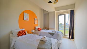 Quarto de hotel com duas camas, uma janela grande com cortinas e vista para o exterior.