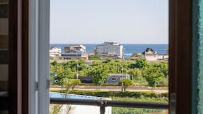 Uma área residencial costeira com edifícios, árvores e vista para o mar.