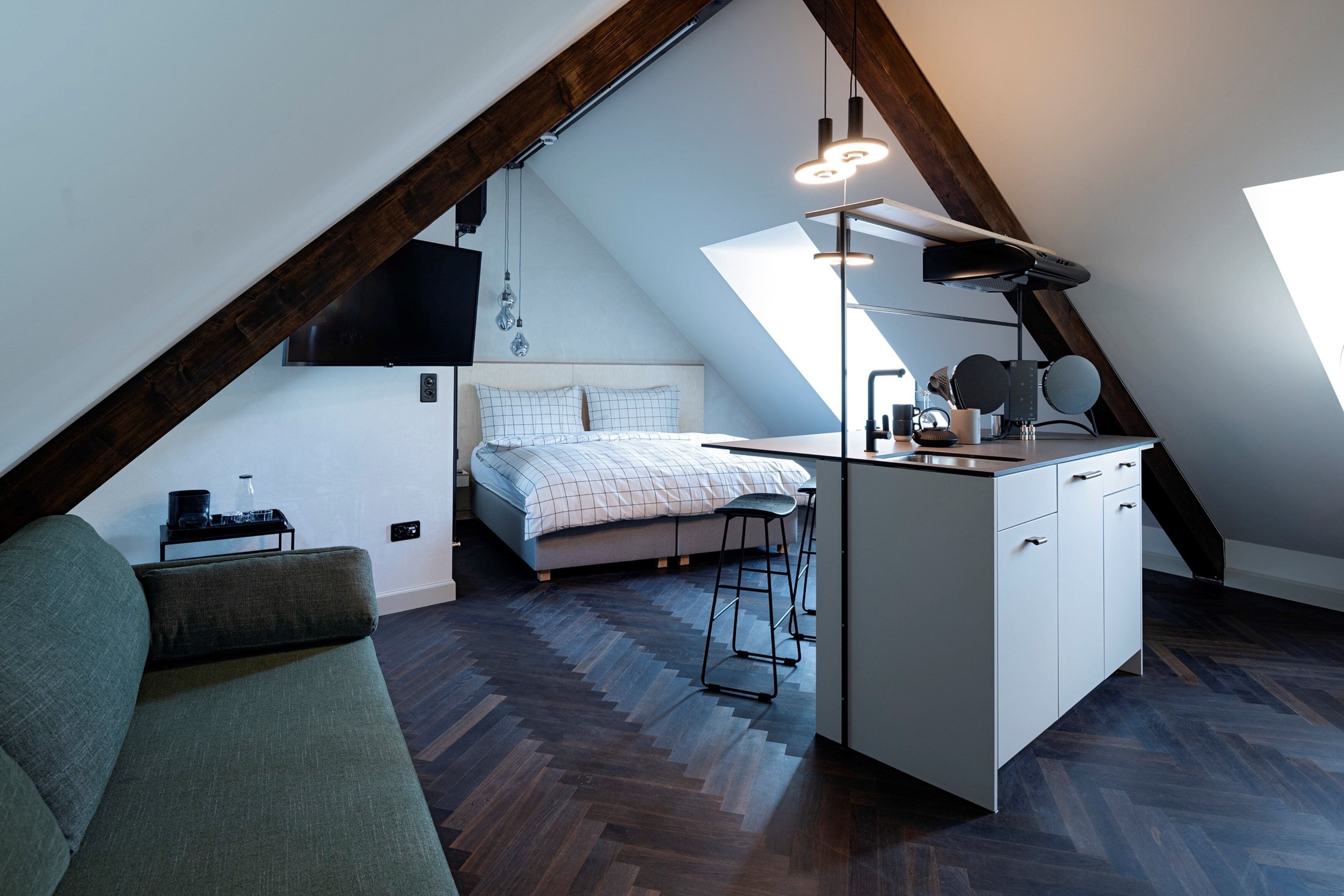 Apartamento loft compacto e moderno, com cama estilo loft, cozinha compacta e área de refeições.