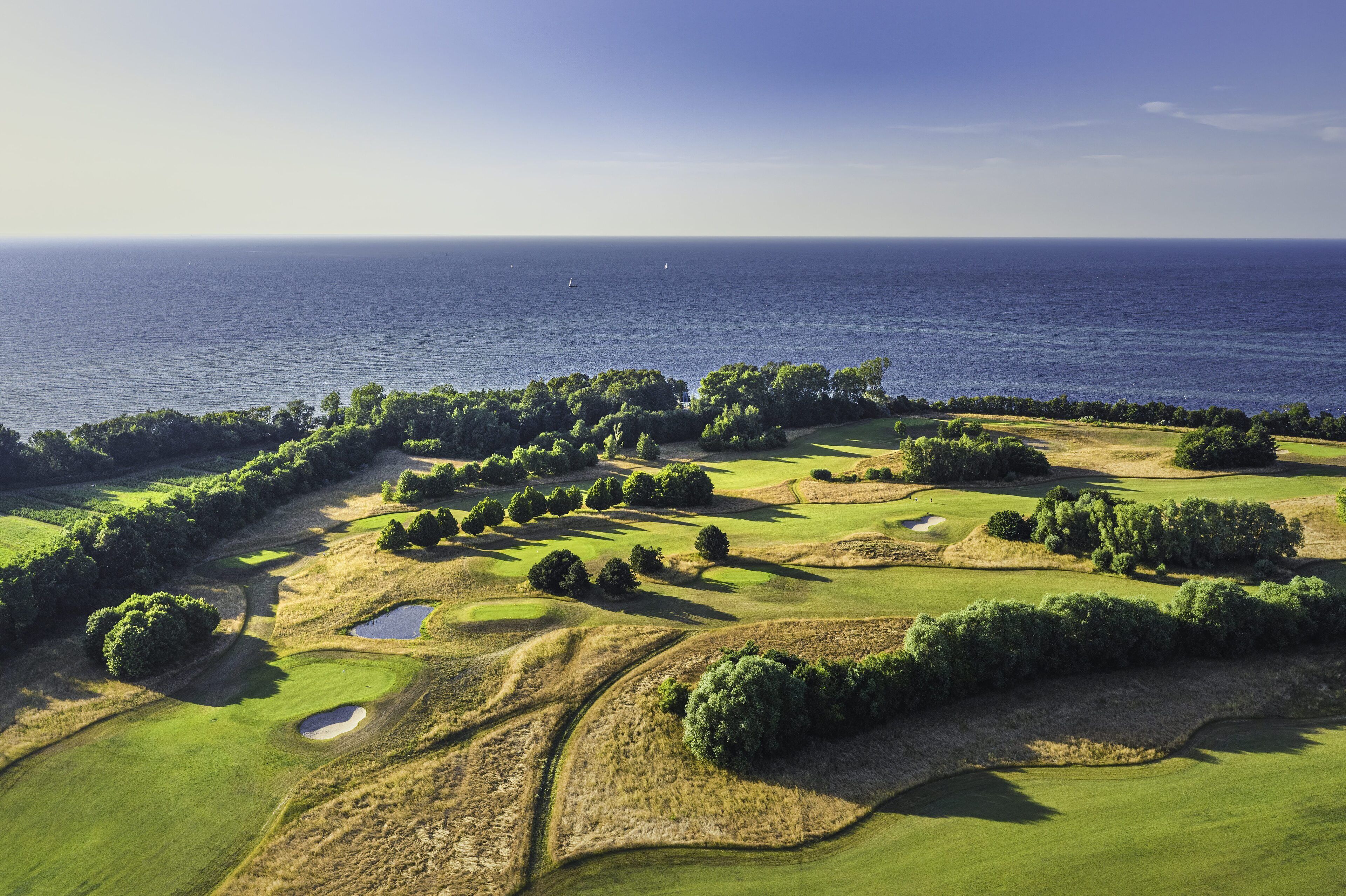 Um campo de golfe com vista para o oceano.