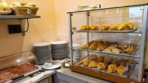 Um buffet de café da manhã com pães e carnes.