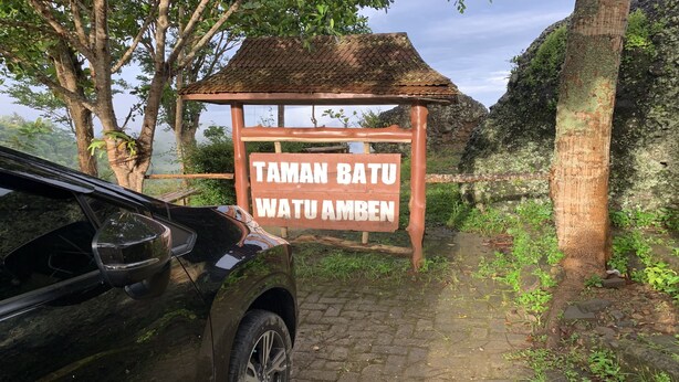 Uma placa com a inscrição 'TAMAN BATU WATU AMBEN' e um carro estacionado próximo.