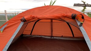 Uma tenda laranja grande com vista para a paisagem.