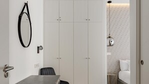 Quarto moderno e minimalista com piso de madeira, cama, mesa de cabeceira e guarda-roupa.
