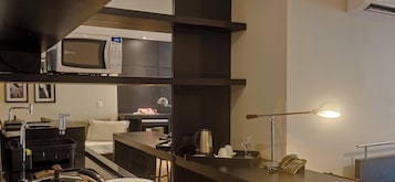 Uma cozinha moderna com micro-ondas, máquina de café e telefone na bancada.