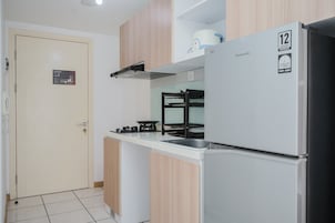 Uma cozinha compacta com forno embutido, geladeira e pia.