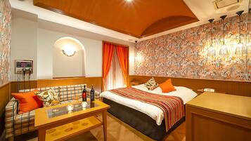 Quarto de hotel com cama, sofá, mesa e televisão.