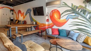 Uma área de estar moderna com um sofá, um banco de madeira e uma mesa pequena.