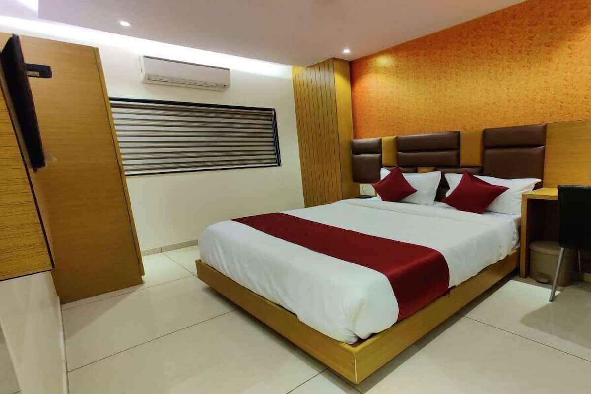 Quarto de hotel moderno com uma cama grande, uma escrivaninha e um guarda-roupa.