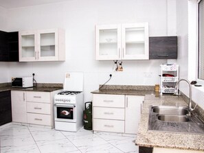 Um frigorífico, um micro-ondas, um forno, uma placa de cozinha 