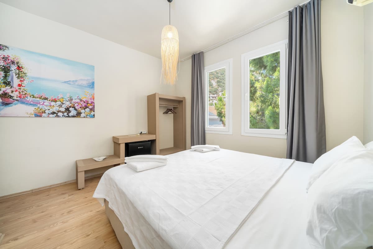 Quarto com cama, mesa de cabeceira e um quadro na parede.