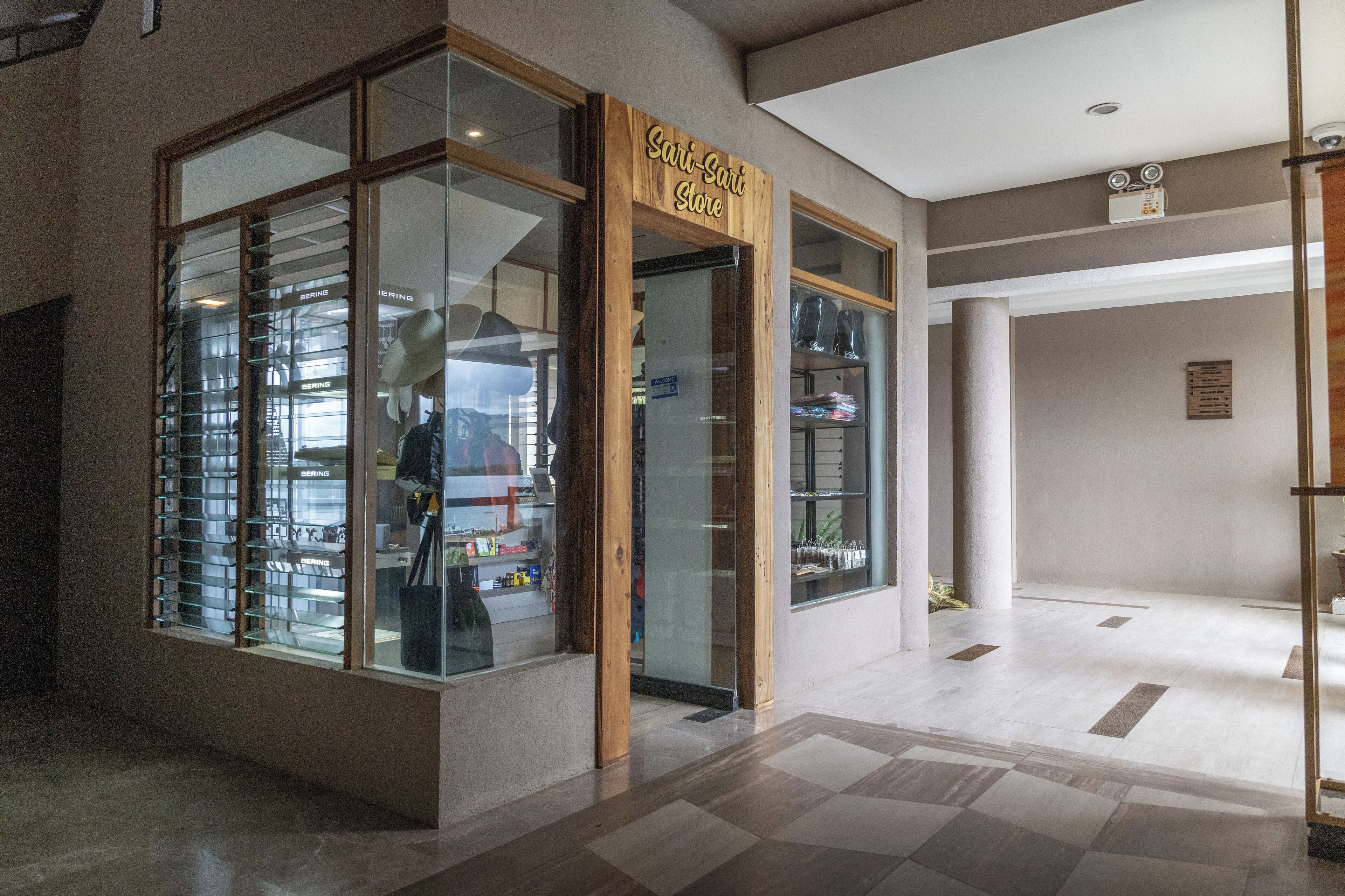 Uma loja chamada "Sari-Sari Store" com janelas de vidro e fachada de madeira.