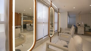 Decoração moderna com balcão de recepção, área de estar e grandes espelhos.