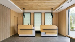 Casa de banho moderna com paredes de madeira, duas pias com bancadas de mármore e luzes pendentes.