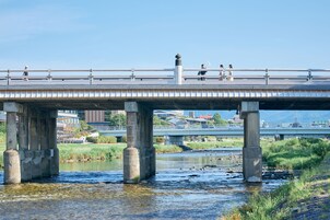 Uma ponte com pilares de concreto sustentando uma passarela sobre um rio.