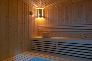 Uma sauna com paredes de madeira e um banco.