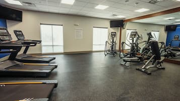 Centro de ginástica com esteiras, elípticos e equipamentos de musculação.