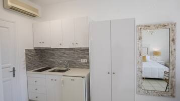 Quarto básico (Kastro) | Cozinha privada | Frigobar, cooktop, cafeteira/chaleira, chaleira elétrica