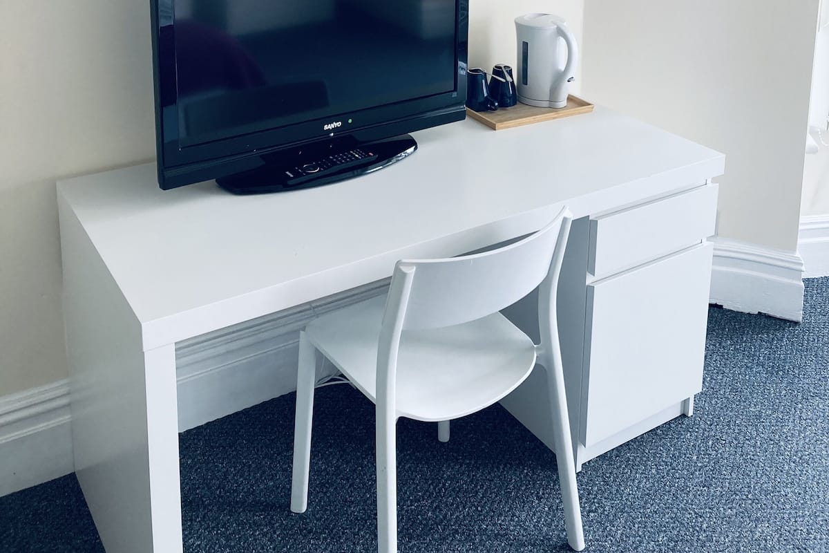 Roupas de cama premium, escrivaninha, espaço de trabalho para notebook