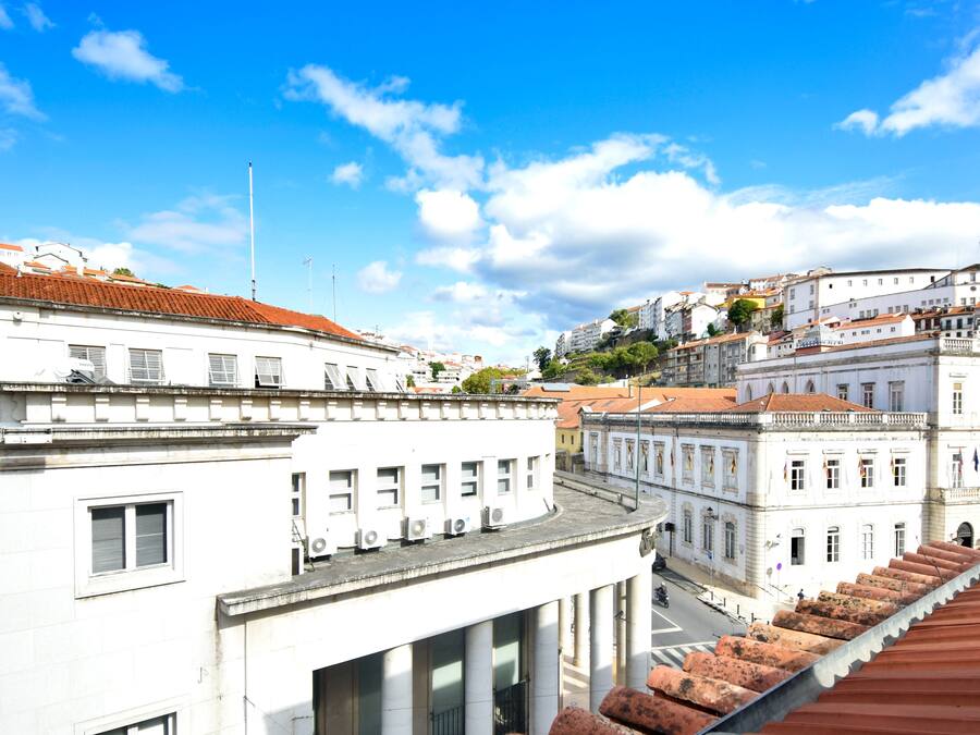 Um edifício histórico com arquitetura clássica, destacando uma entrada central imponente e uma série de janelas ao longo da fachada.