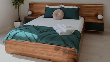 Quarto moderno com estrutura de cama de madeira, uma planta em vaso e mesa de cabeceira com abajur.
