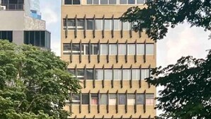 Um edifício de hotel moderno com fachada plana, várias janelas e entrada visível.