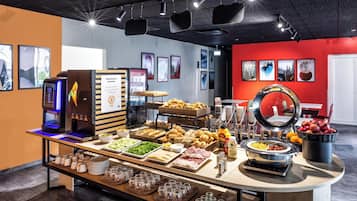 Buffet de café da manhã com diversas opções de alimentos, uma máquina de café e um aviso indicando opções sem glúten.