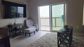 Apartamento em Condomínio Fechado, várias camas, varanda, vista para o oceano | Sala de estar | Televisor