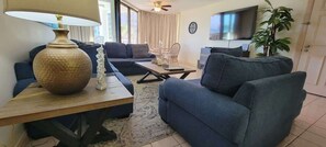 Apartamento, várias camas, varanda, vista para a piscina | Sala de estar | Televisor 