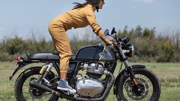 Uma pessoa conduzindo uma motocicleta em um campo aberto.