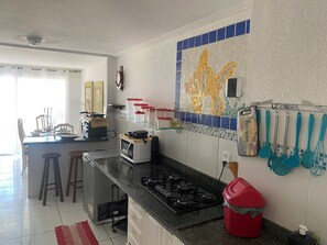 Um frigorífico/congelador grande, um micro-ondas, uma placa de cozinha 
