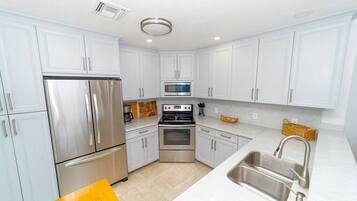 Apartamento em Condomínio Fechado, vista para a praia | Cozinha privada | Um frigorífico/congelador grande, um micro-ondas, um forno