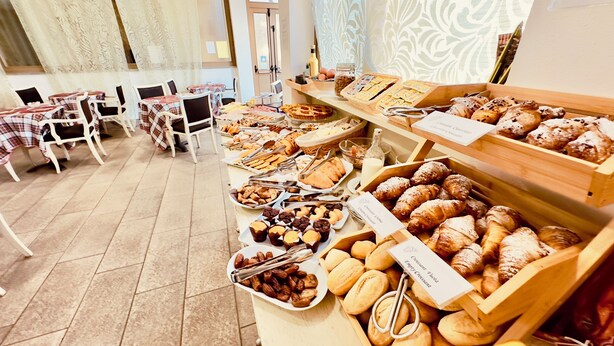 Um buffet com diversos produtos de panificação e pastelaria.