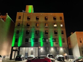 Um edifício de vários andares com design moderno, caracterizado por uma série de janelas e uma entrada destacada.