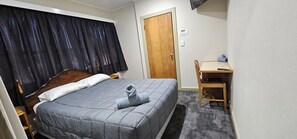 Um quarto com uma cama, uma escrivaninha e uma cadeira.