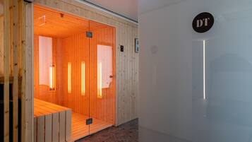 Uma sauna de madeira com um banco, uma porta e uma placa fixada na parede.