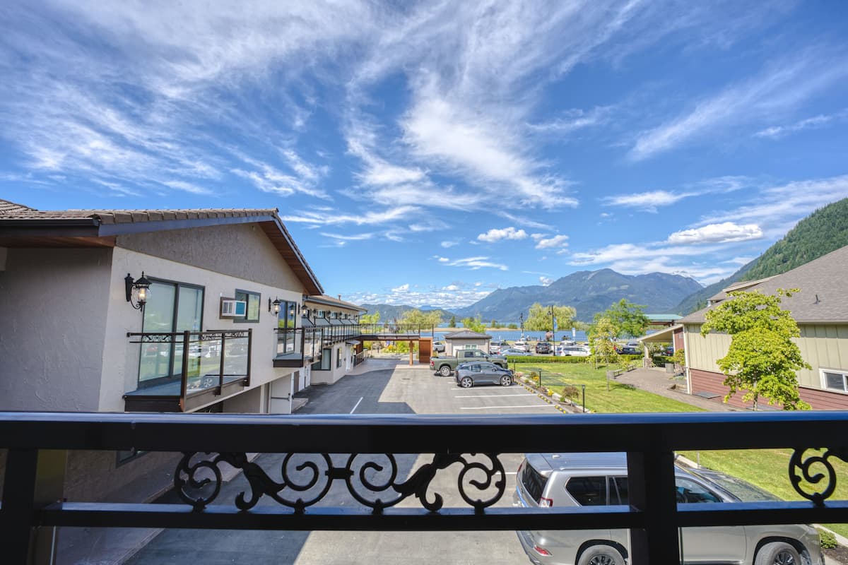 Hotel com estacionamento, vista para montanhas e céu claro.