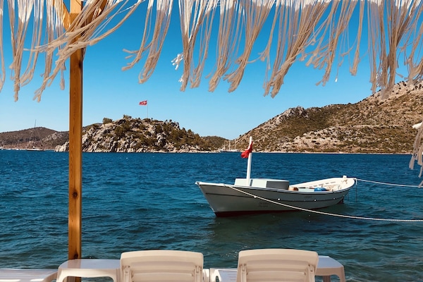 Uma praia privada, espreguiçadeiras, guarda-sóis de praia