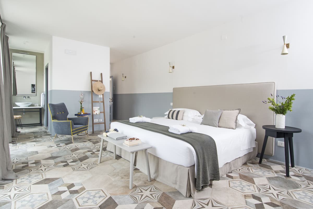 Quarto de hotel moderno com uma cama grande, uma escrivaninha e uma cadeira.