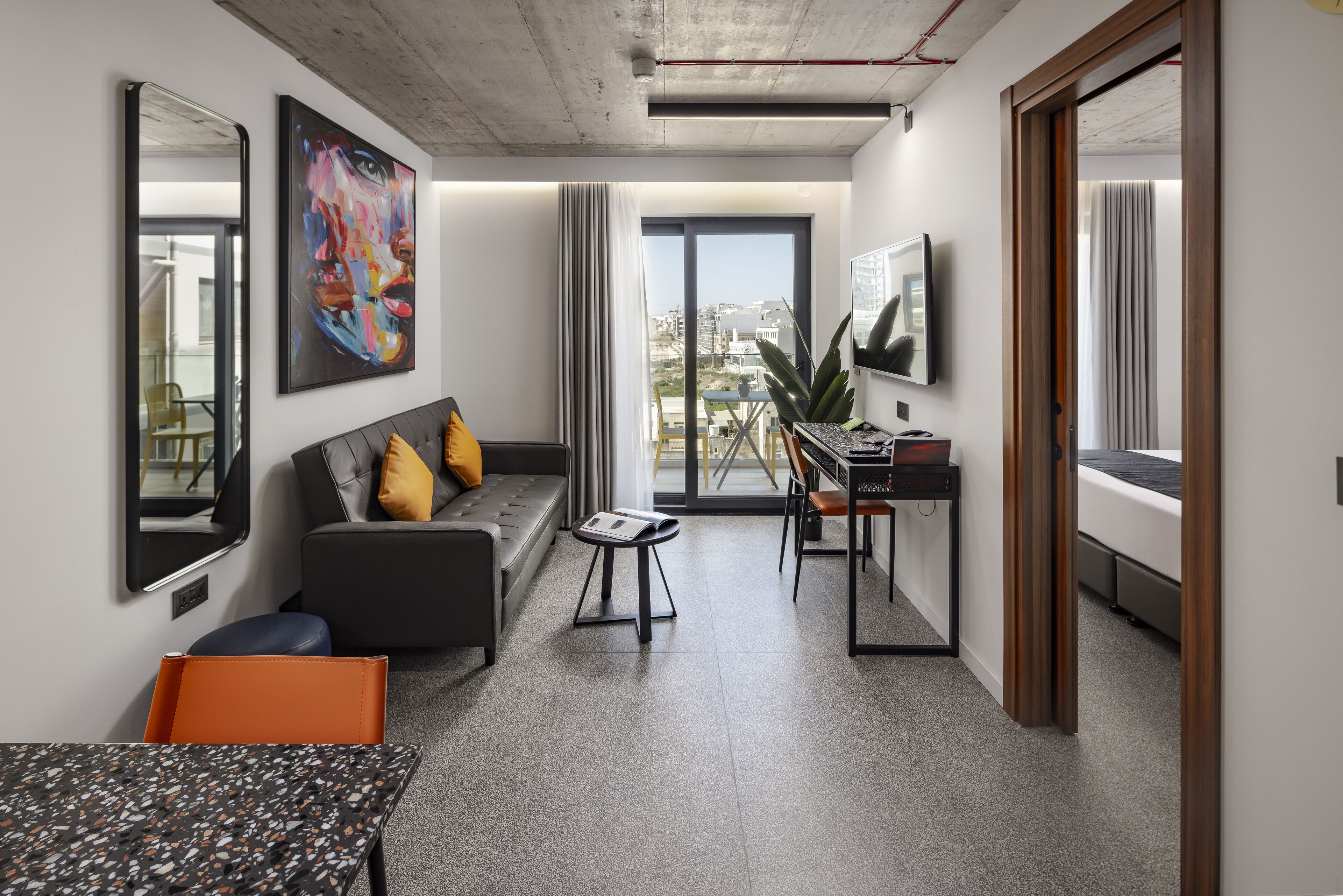 Uma sala de estar moderna com um sofá, uma mesa de centro e uma área de jantar com uma mesa e cadeiras.