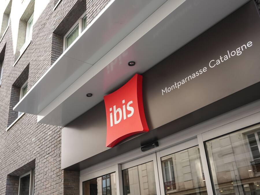 Fachada de hotel com a sinalização 'ibis HOTEL' e o texto 'Montparnasse Catalogue'.